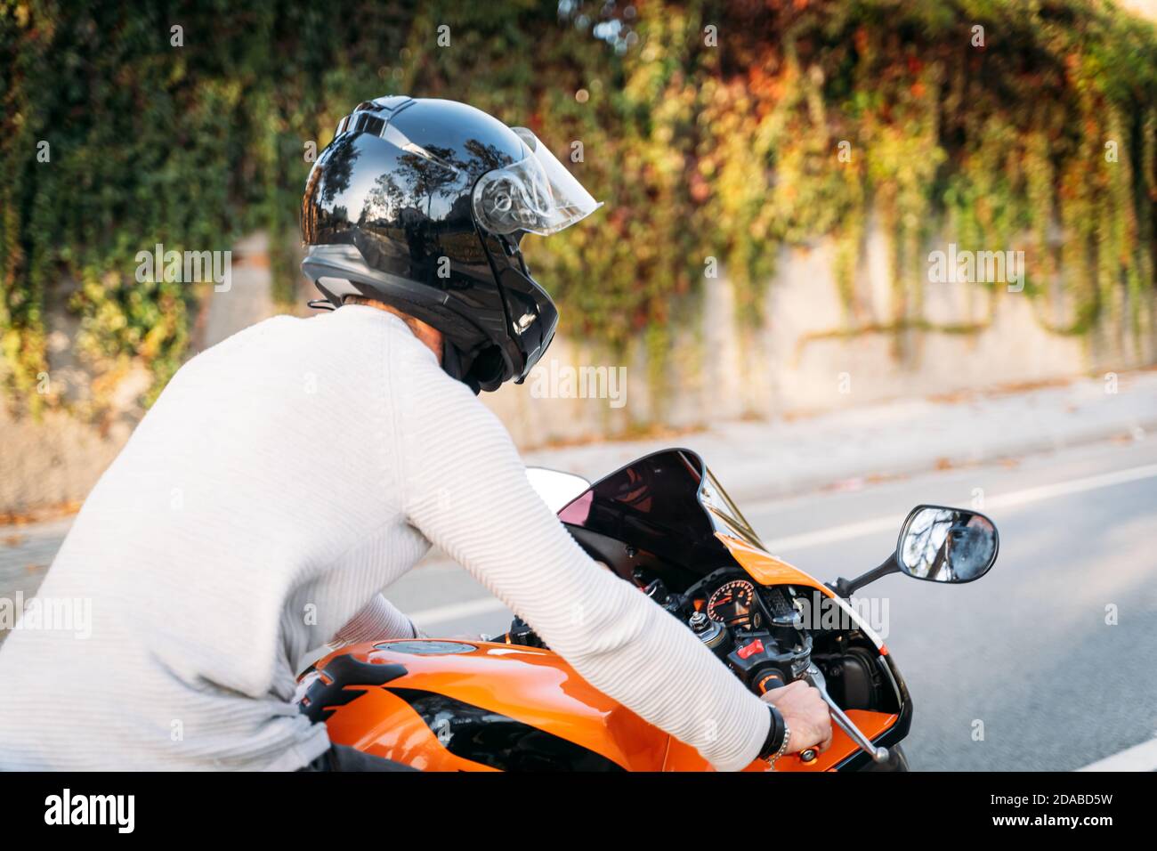Back of a man in a helmet driving a motorcycle on the road Stock Photo ...