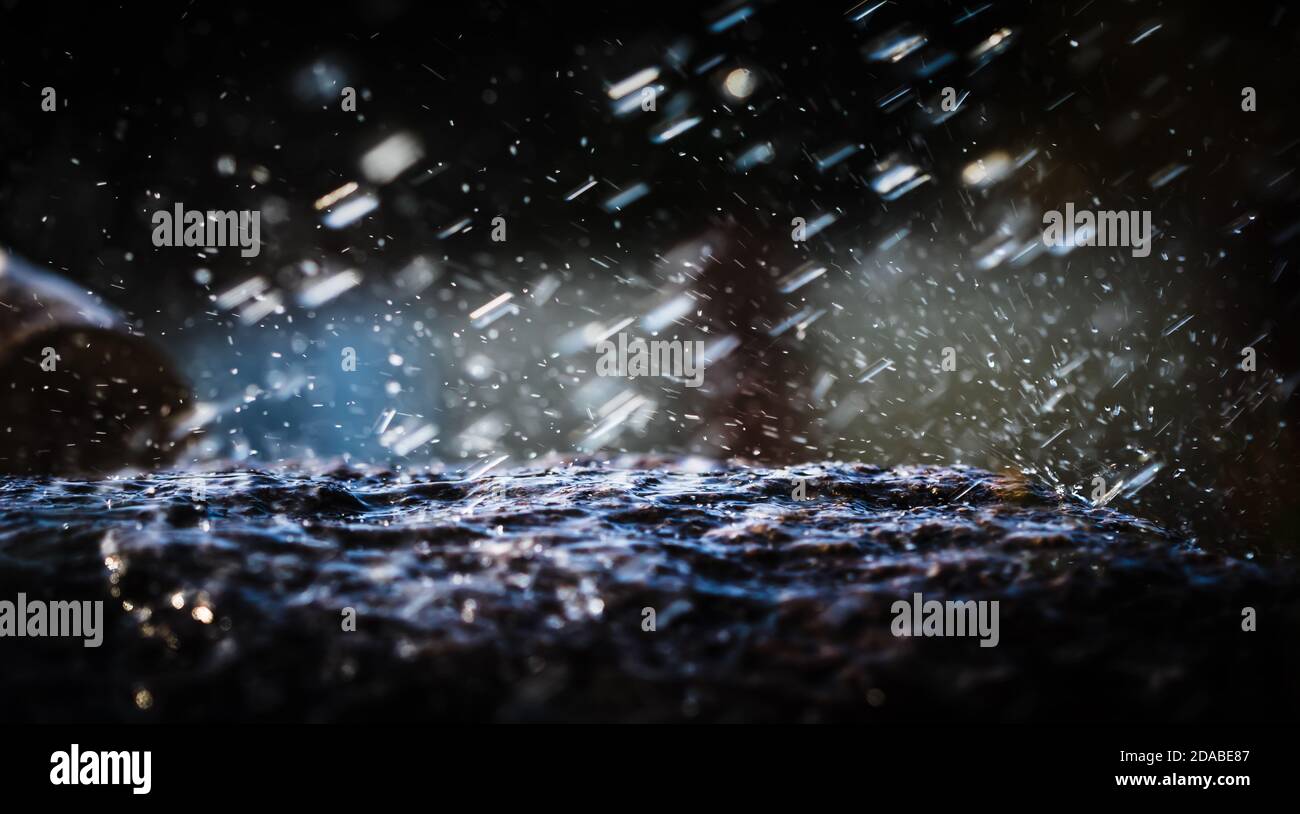 Wet stone in the rain. Rain water drop falling to the stone. Water is ...