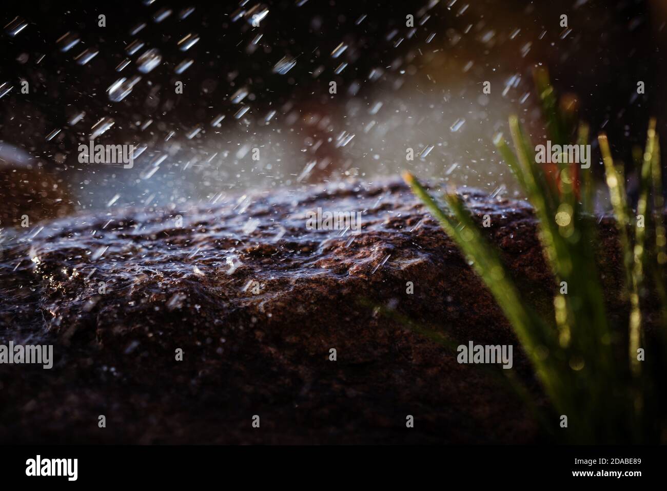 Wet stone in the rain. Rain water drop falling to the stone. Water is ...