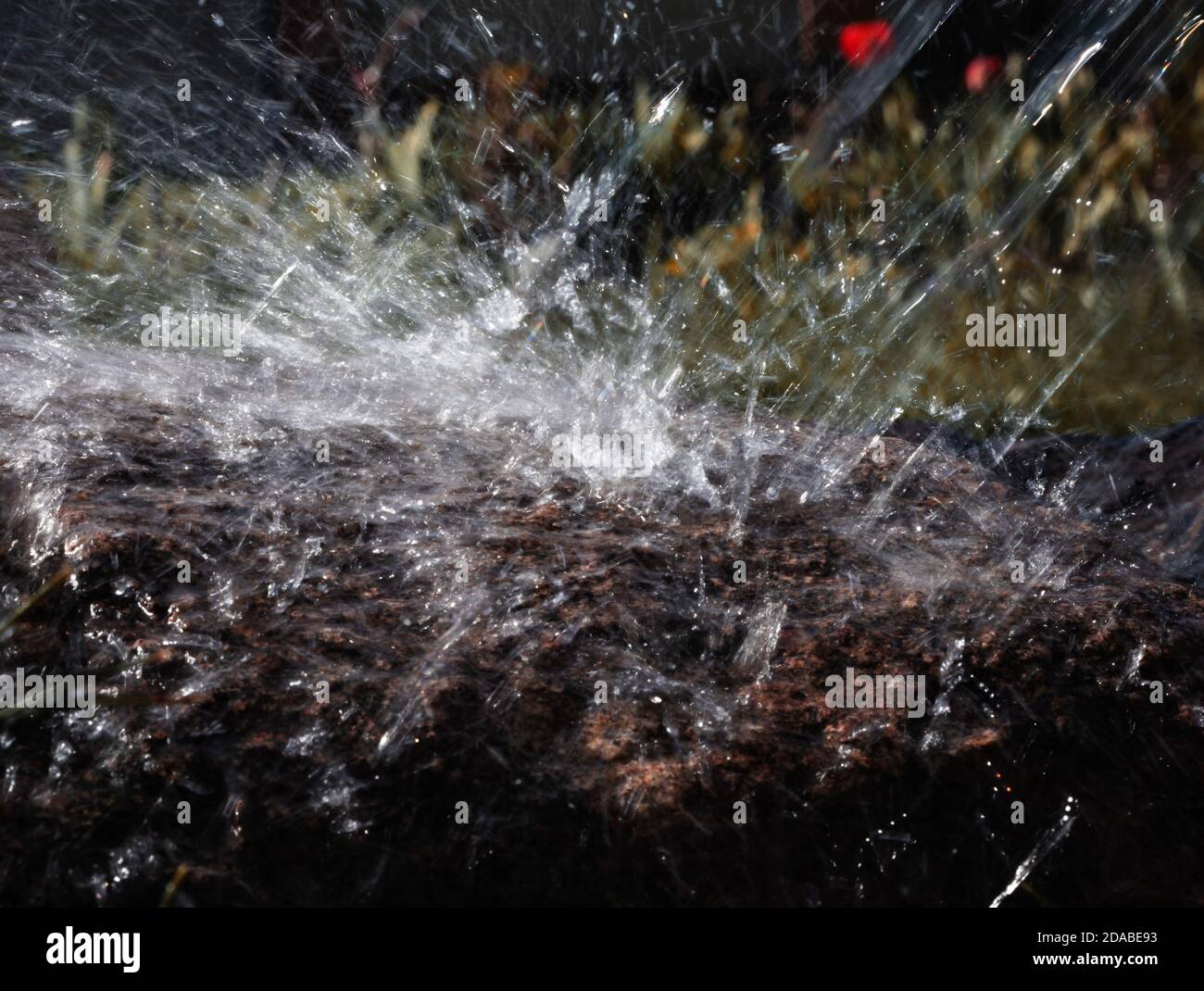 Wet stone in the rain. Rain water drop falling to the stone. Water is ...