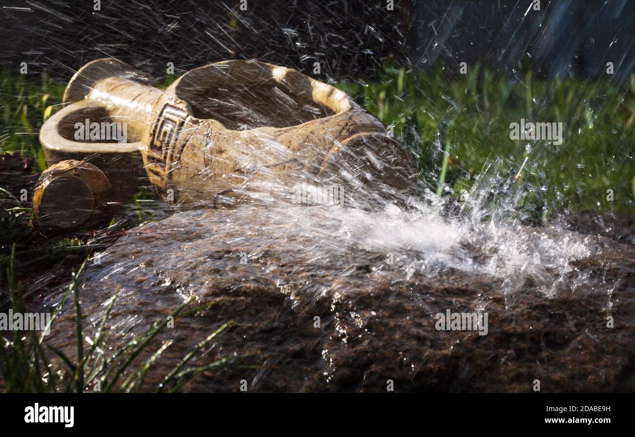 Wet stone and decorative antique urn in the rain. Rain water drop ...
