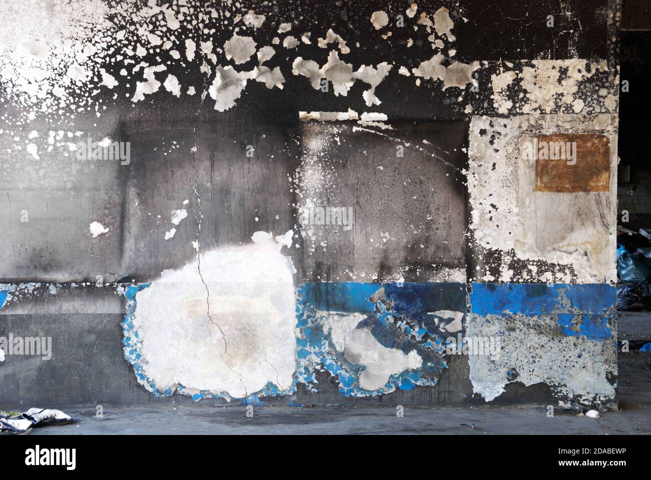 Decay concrete wall in abandoned factory partially covered by soot ...