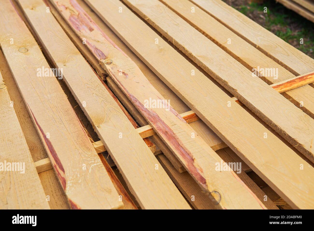 Building material in the form of fresh wooden planks at a road repair ...