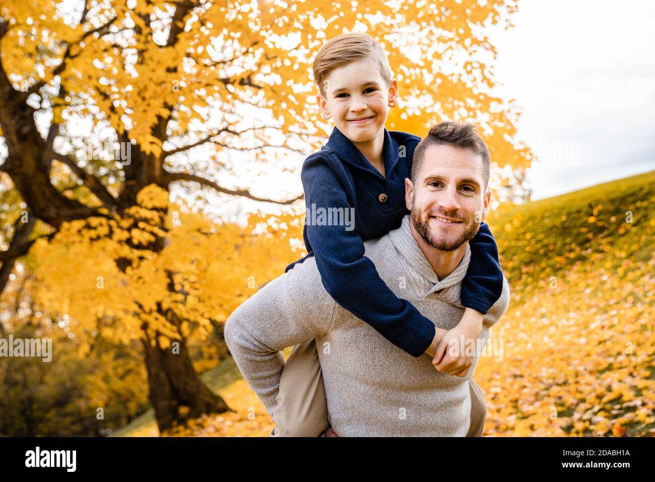 Happy family father and child boy in the autumn leaf fall in park ...