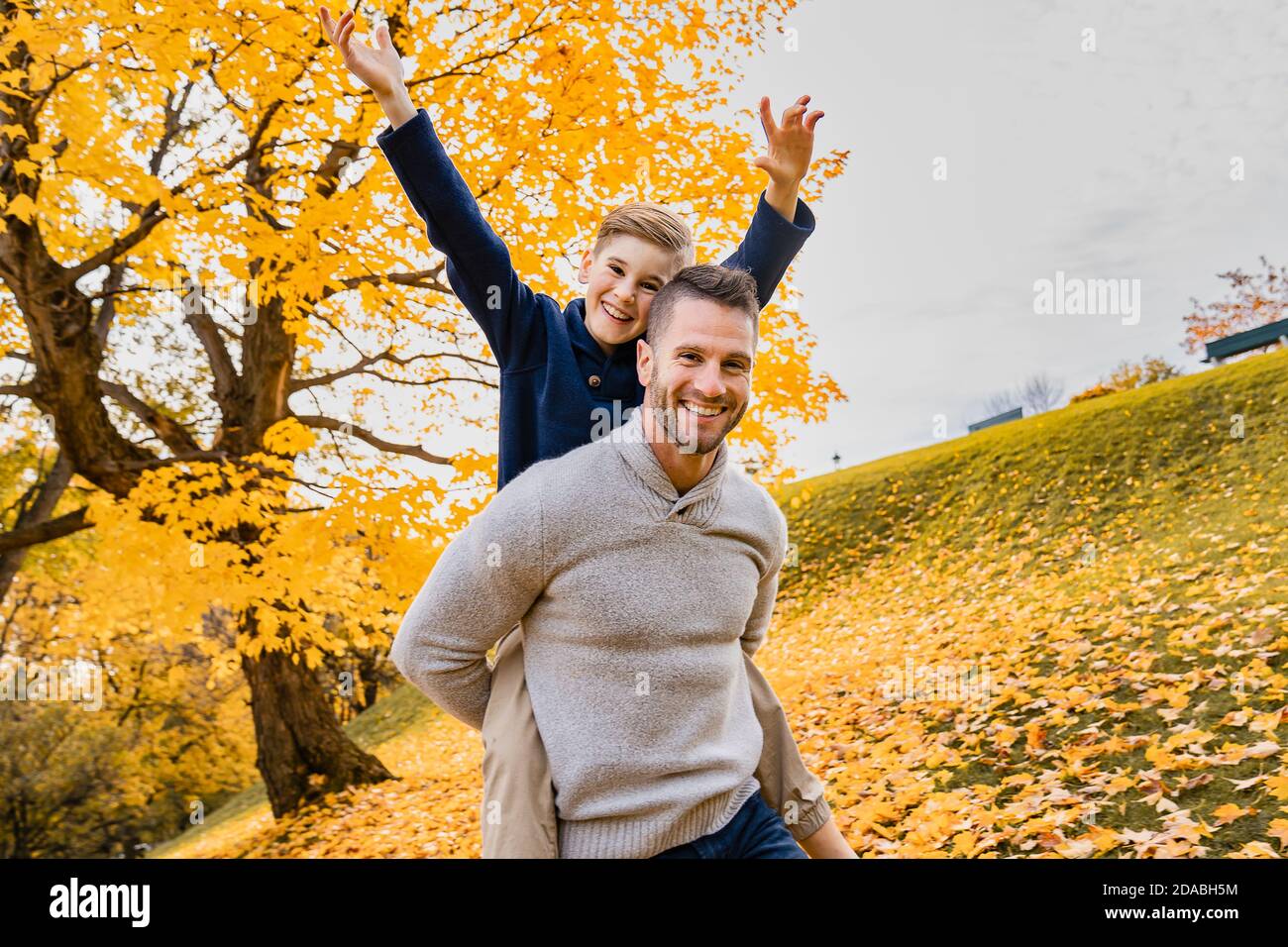 Happy family father and child boy in the autumn leaf fall in park ...