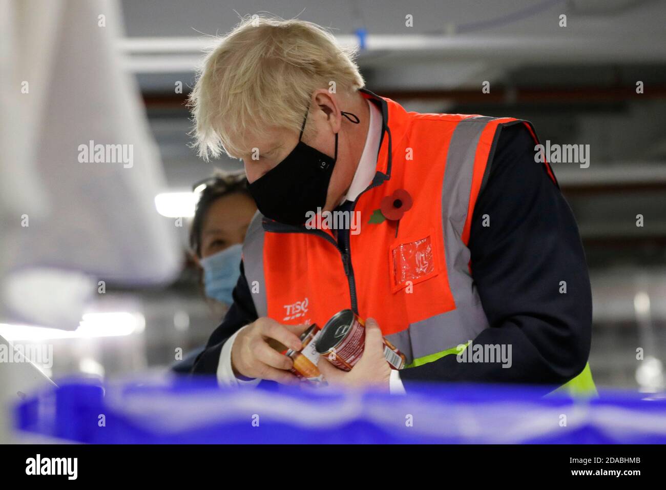 Prime Minister Boris Johnson loads produce into baskets during a visit ...