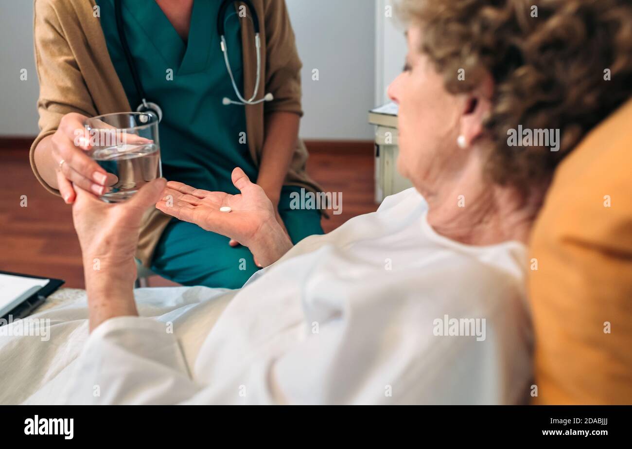 Doctor giving medication dose to elderly patient Stock Photo - Alamy