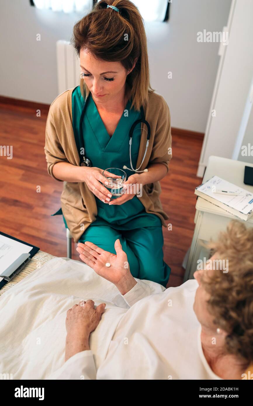Doctor giving medication dose to elderly patient Stock Photo - Alamy