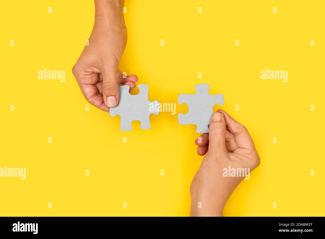 Woman hands holding puzzle pieces on a yellow background Stock Photo ...