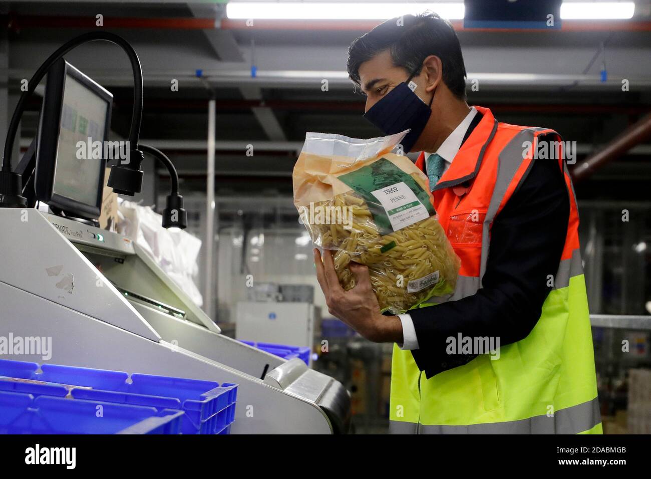 Chancellor of the Exchequer Rishi Sunak loads produce into baskets ...