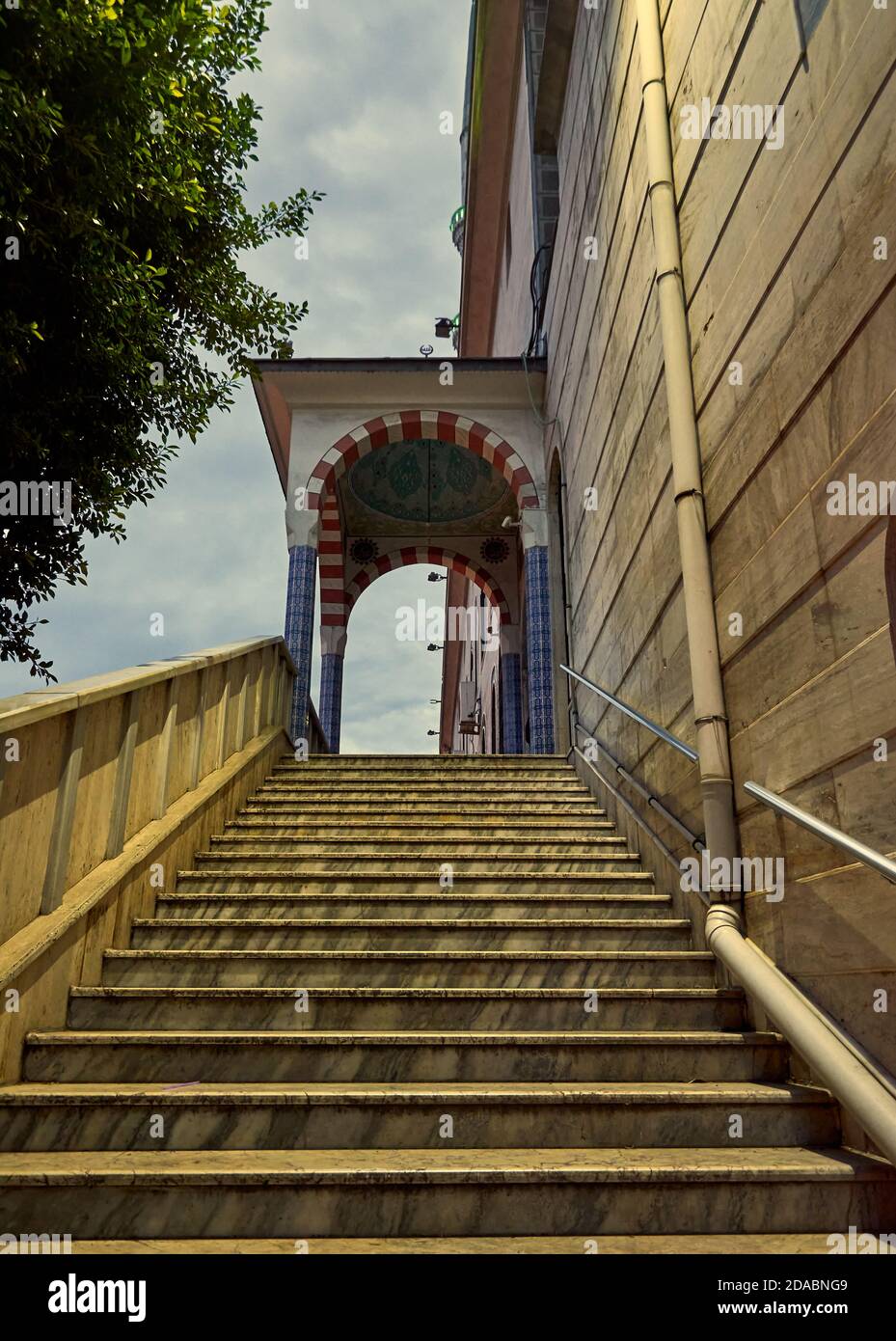 Vertical shot of stairs leading up to a decorative arched dome entrance ...