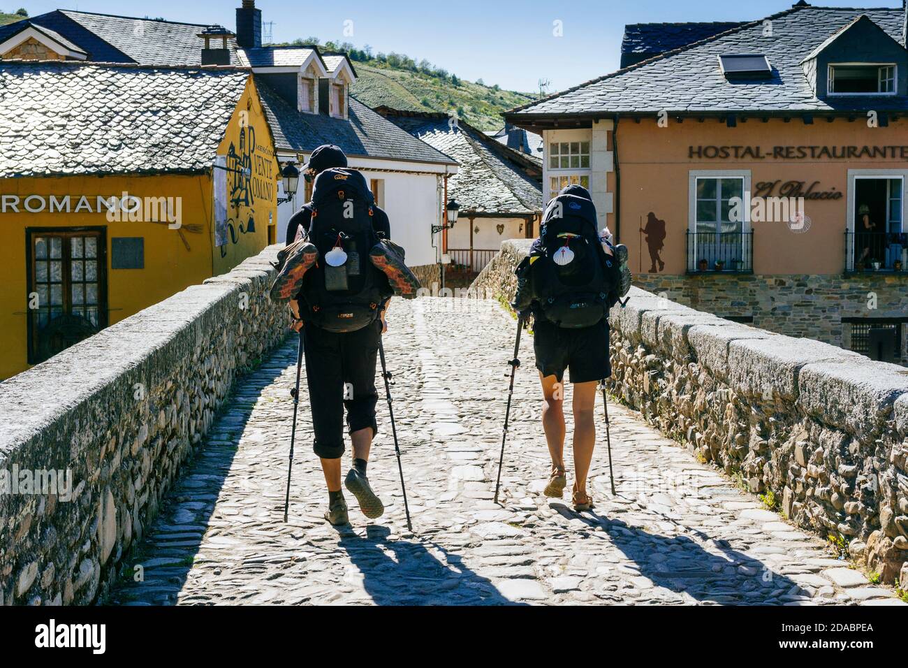 Couple of pilgrims walking on the Medieval Bridge or Pilgrims Bridge ...