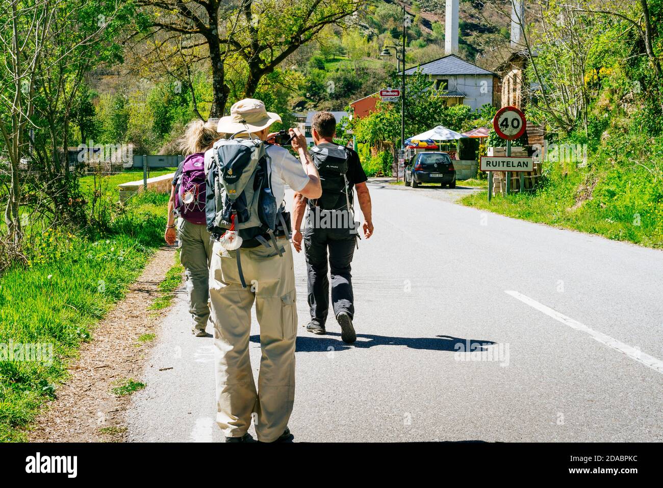 Pilgrims walk along the left side of the road between the towns of ...