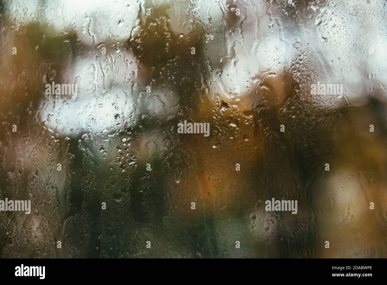 Blurred reflection of the street in a misted window, drops of water ...