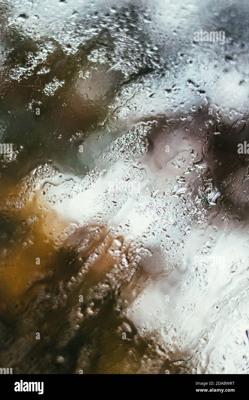 Blurred reflection of the street in a misted window, drops of water ...
