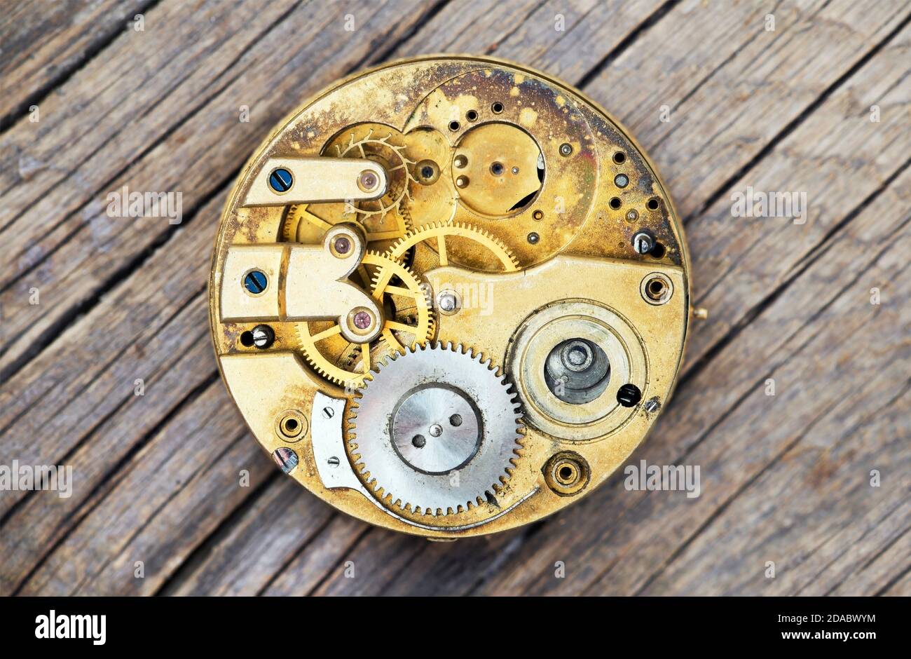 Antique metal pocket watch clockwork with gears on wooden background ...