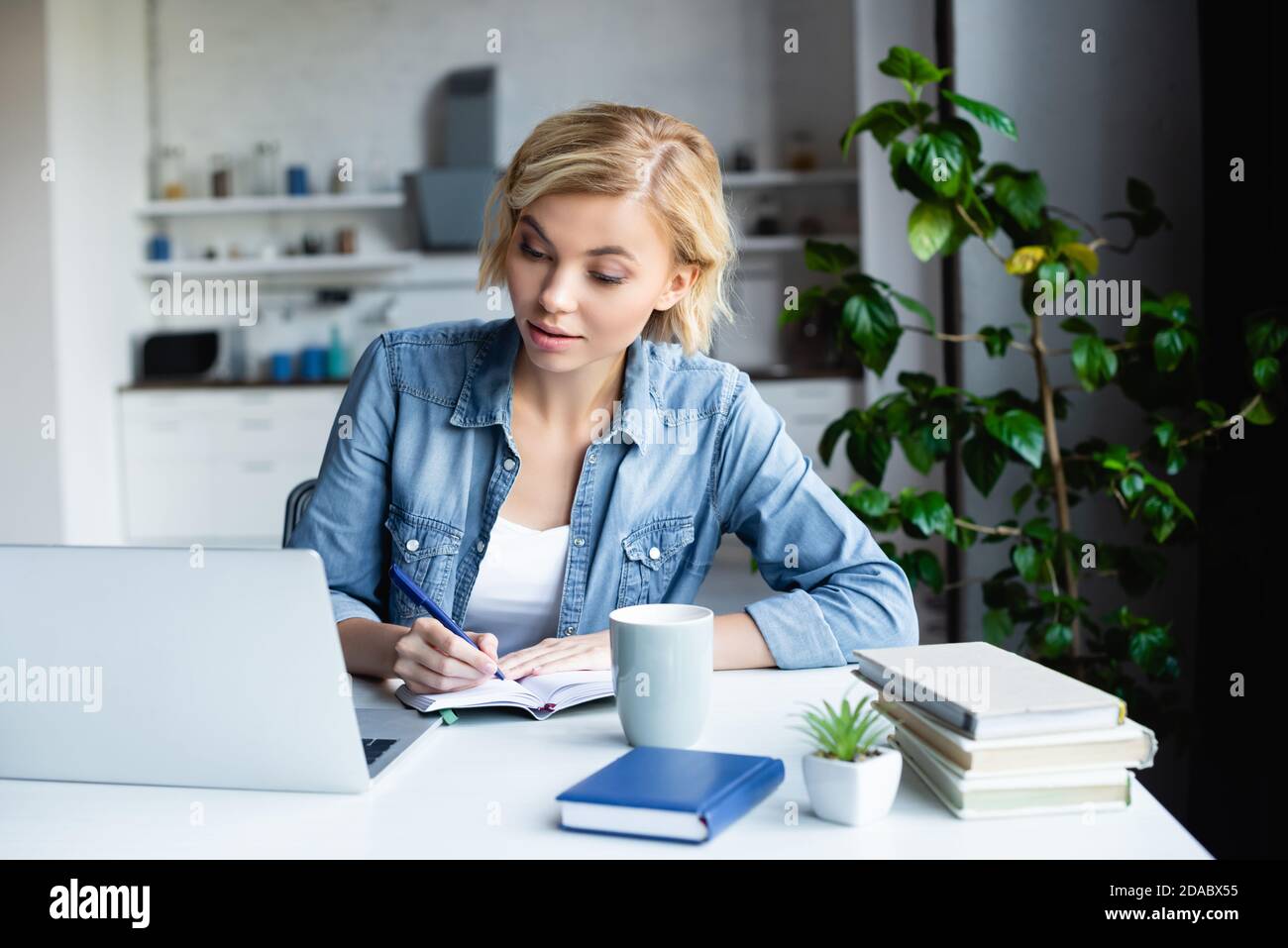 Beautiful young woman studying at desk in library Stock Photo - Alamy