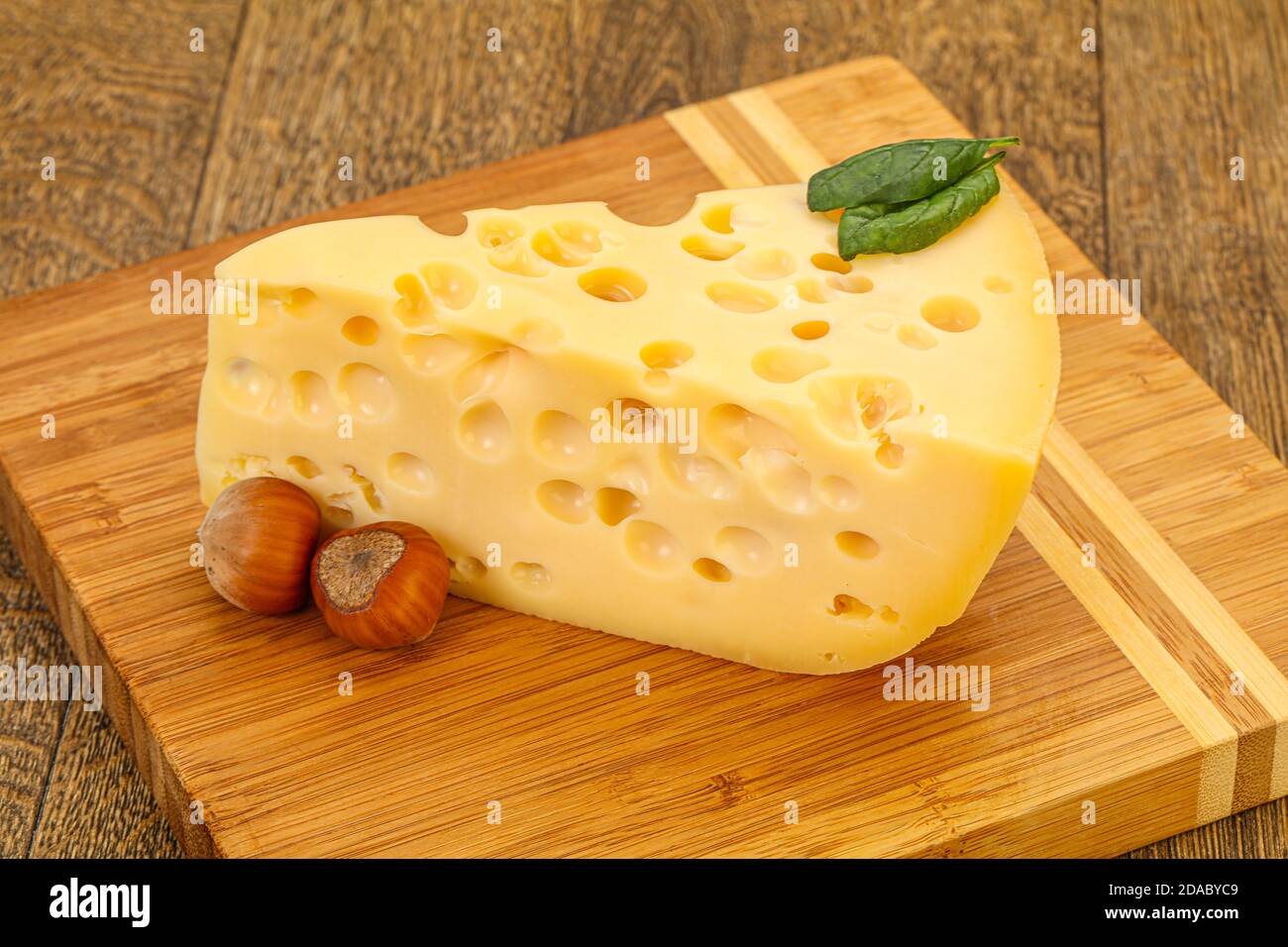 Maasdam cheese - dairy yellow triangle with holes Stock Photo - Alamy