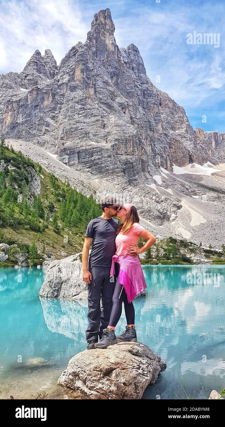 Couple kissing and standing on a rock against a mountain Stock Photo ...