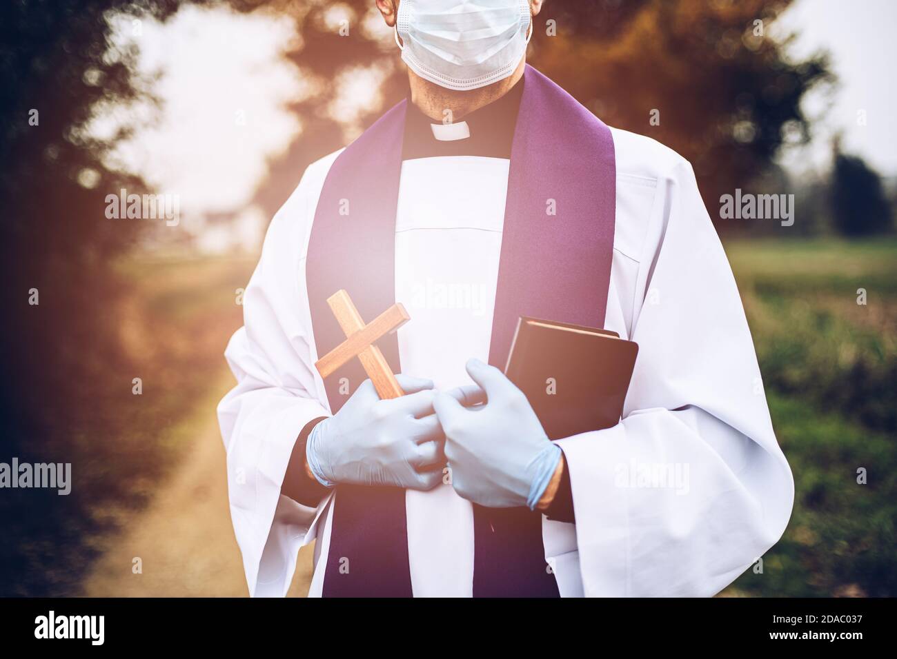 Man priest with a cross in a protective glovesa and medical mask Stock ...
