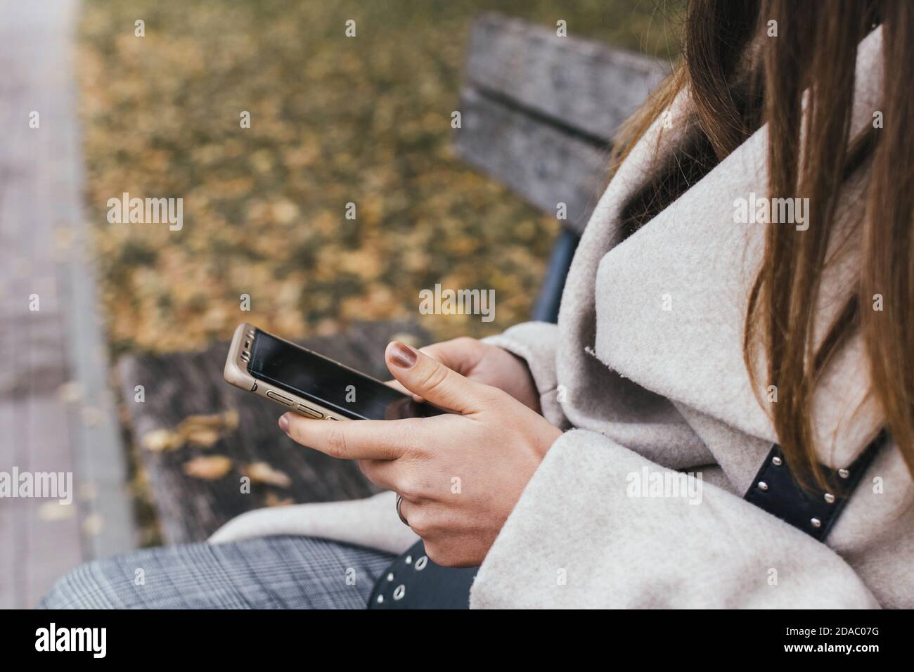 Closeup focus shot of a woman texting on her phone at a park Stock ...