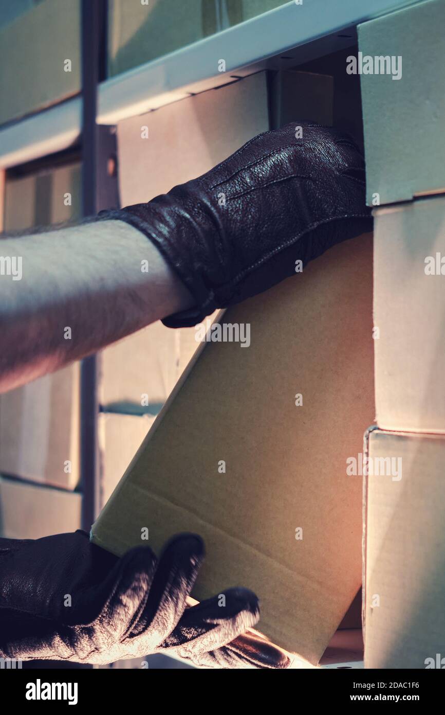 Hands of a man in gloves steal a box with a parcel in a warehouse in ...