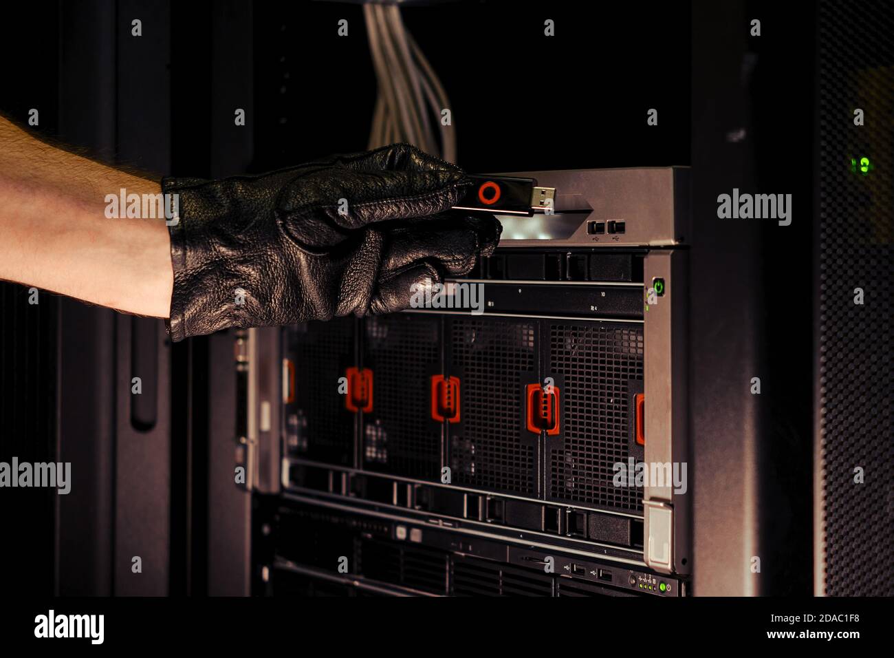 Hand with a flash drive from a hacking device at the server. Concept of ...