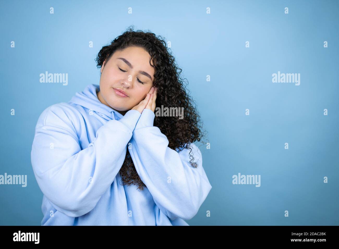 Young beautiful woman wearing casual sweatshirt over isolated blue ...
