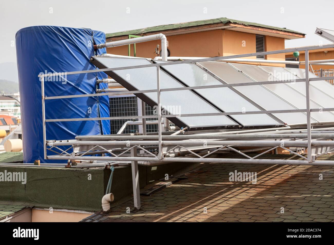 Solar glass water panel array mounted on a roof for heating. Huge tank ...
