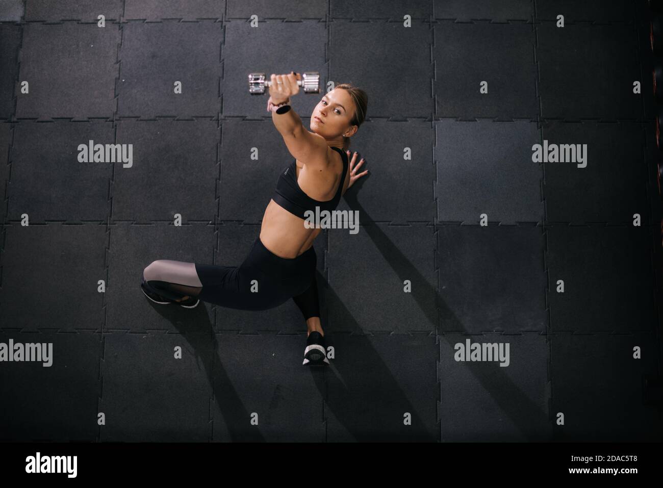 Top down view of strong young woman with athletic body lying on floor ...