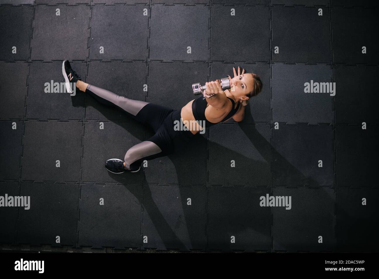Top down view of strong young woman with athletic body lying on floor ...