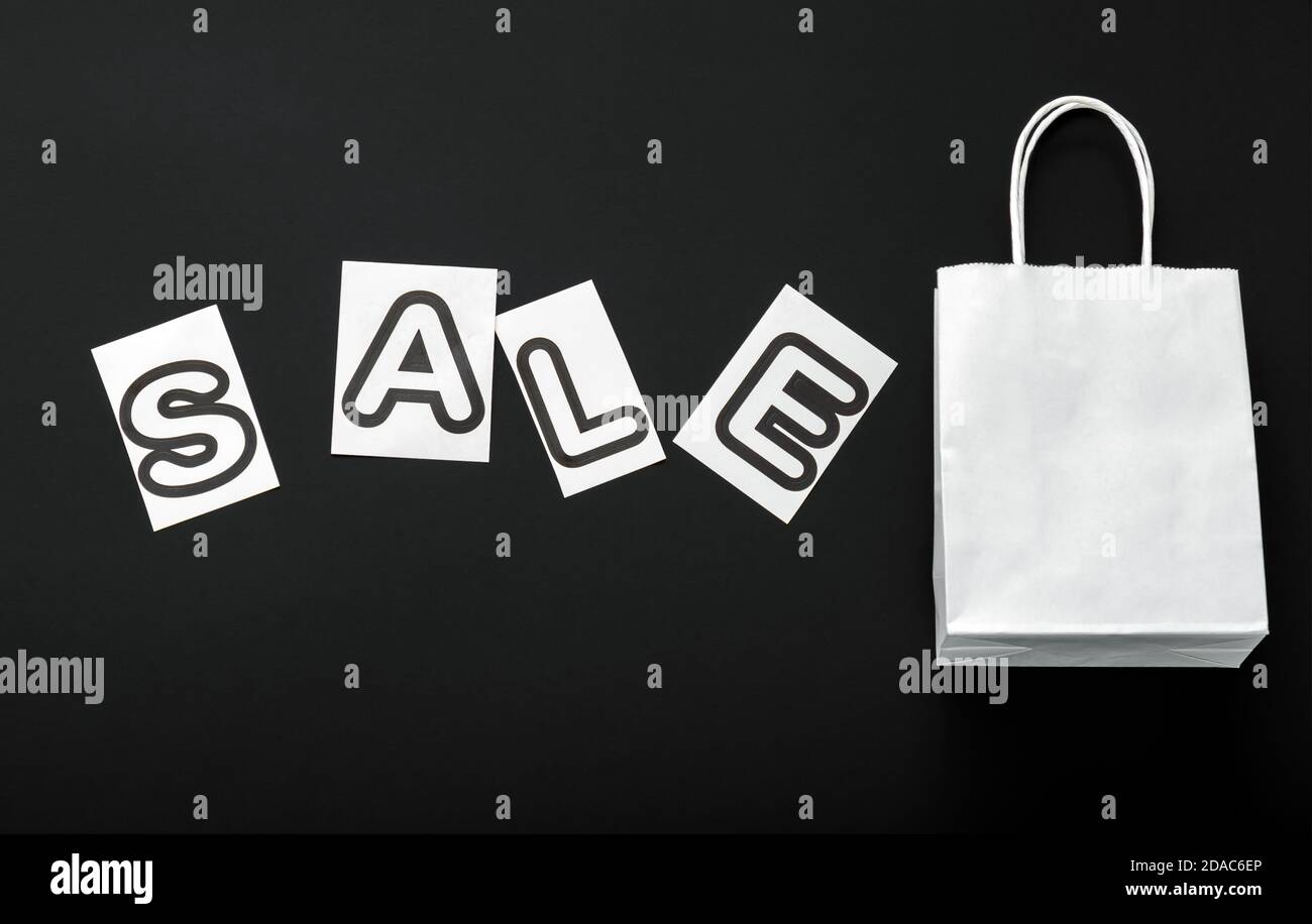 Sale text with white shopping paper bag on black background. Delivery ...