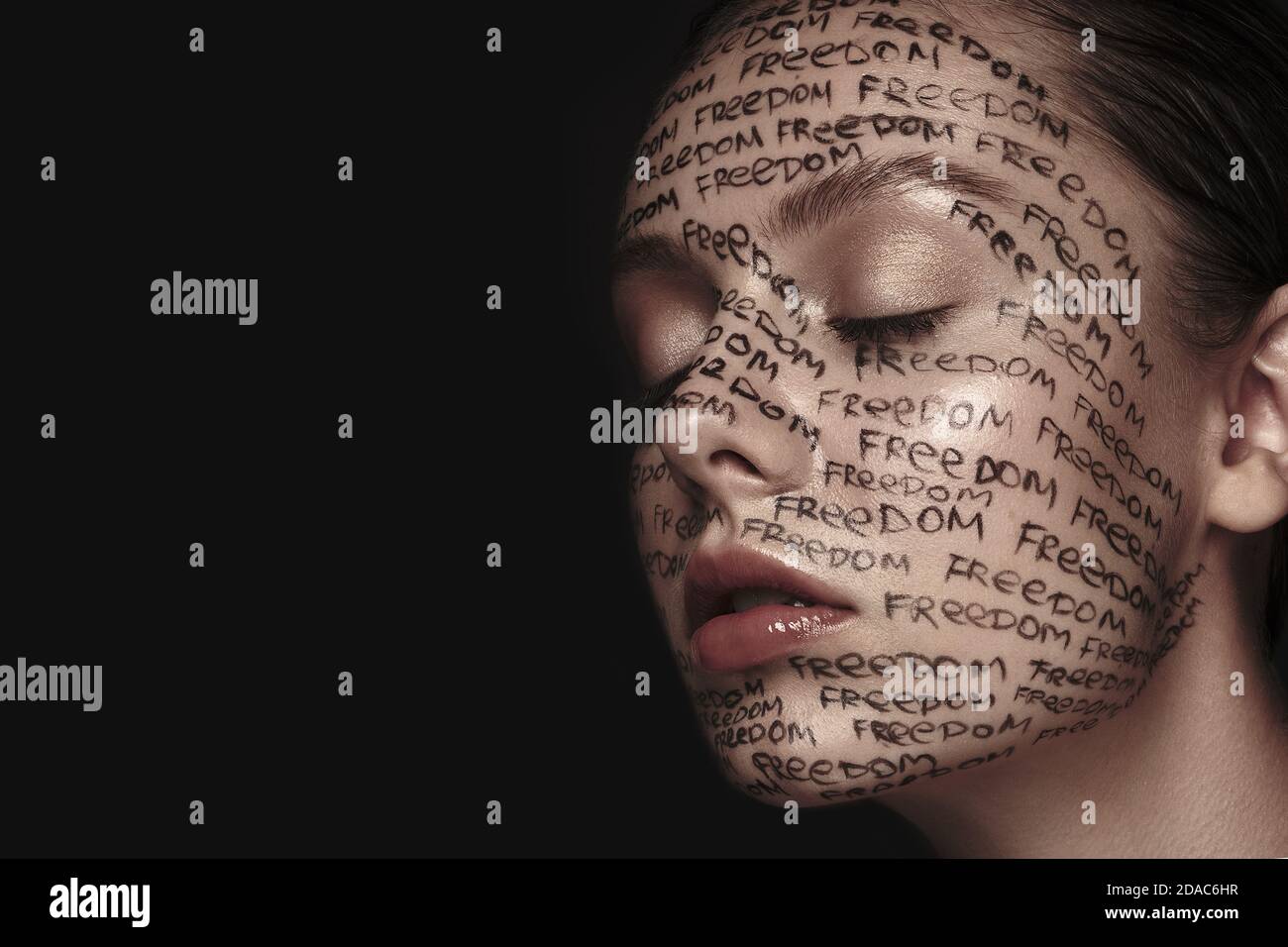 Portrait of beautiful woman with painted words on her face. Art make-up ...