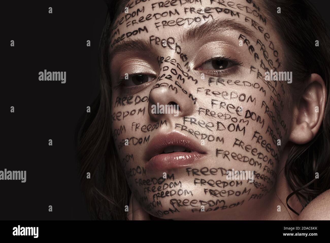 Portrait of beautiful girl with painted words on her face. Art make-up ...