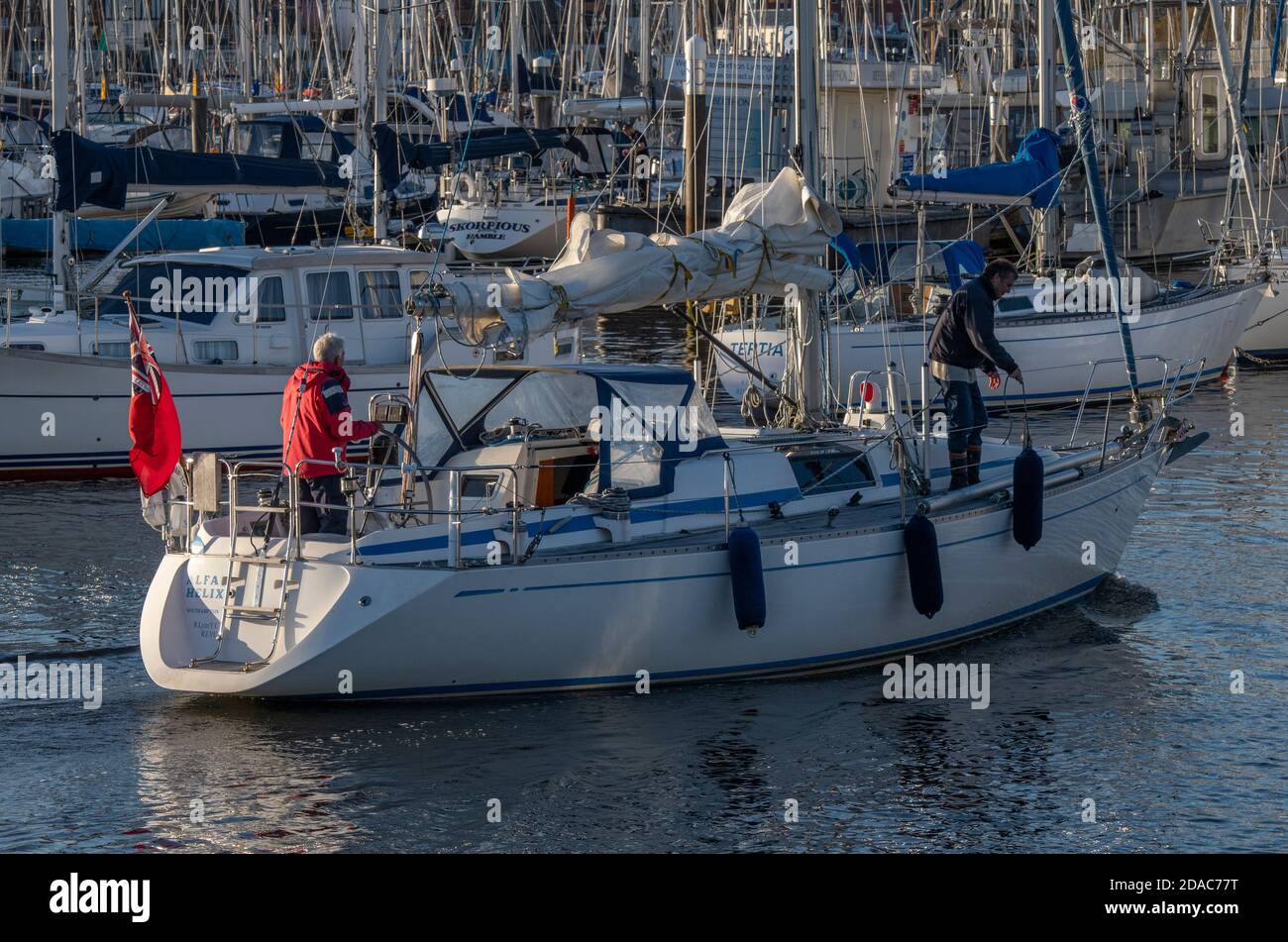 a yachtsman on a large yacht entering the yacht marina at lymington ...