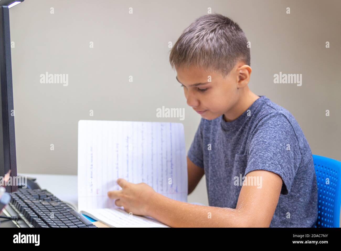 Teenage boy learning, turning pages of notebook, doing homework ...