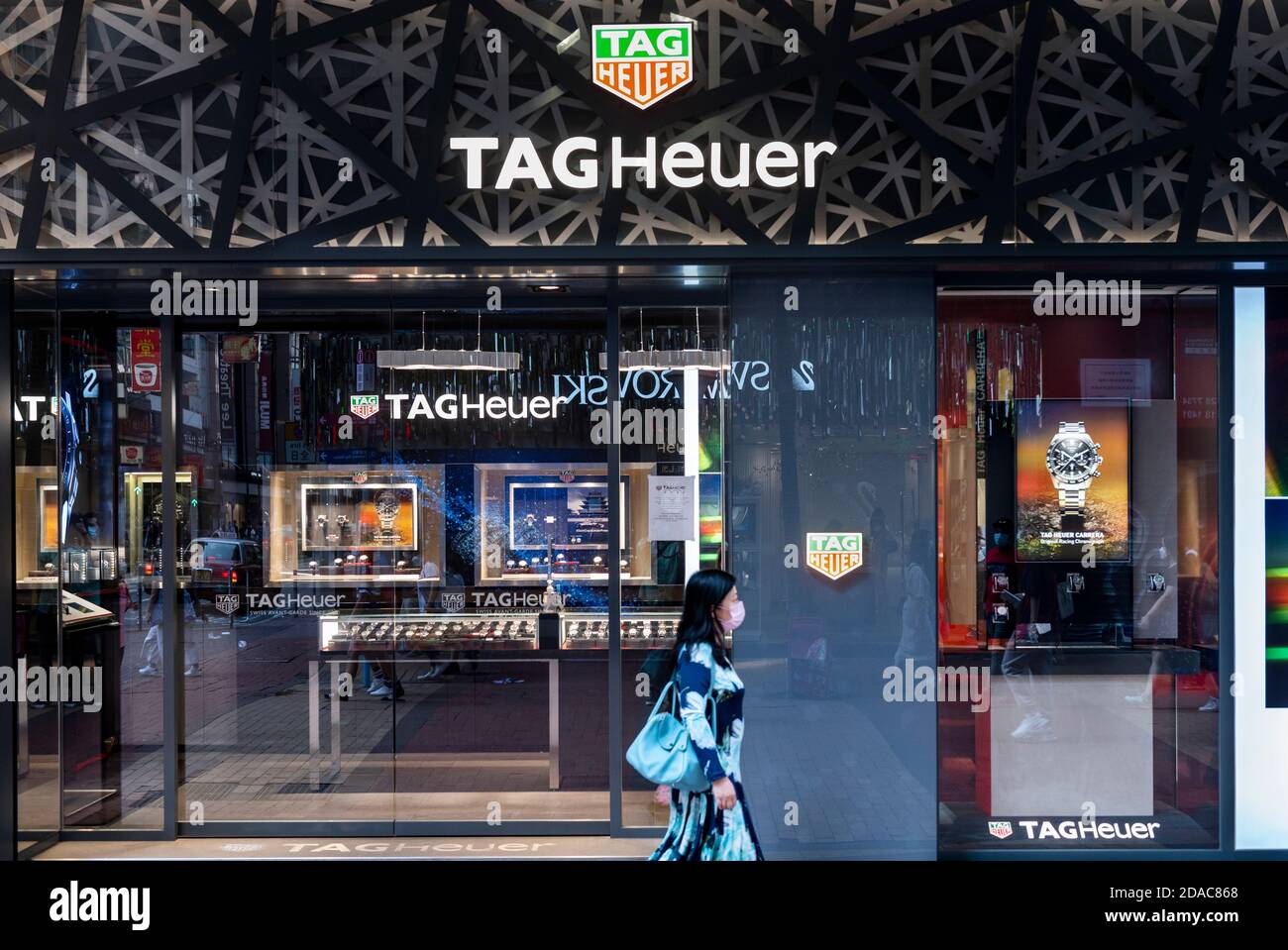 A pedestrian wearing a face mask walks past the Swiss luxury watchmaker ...