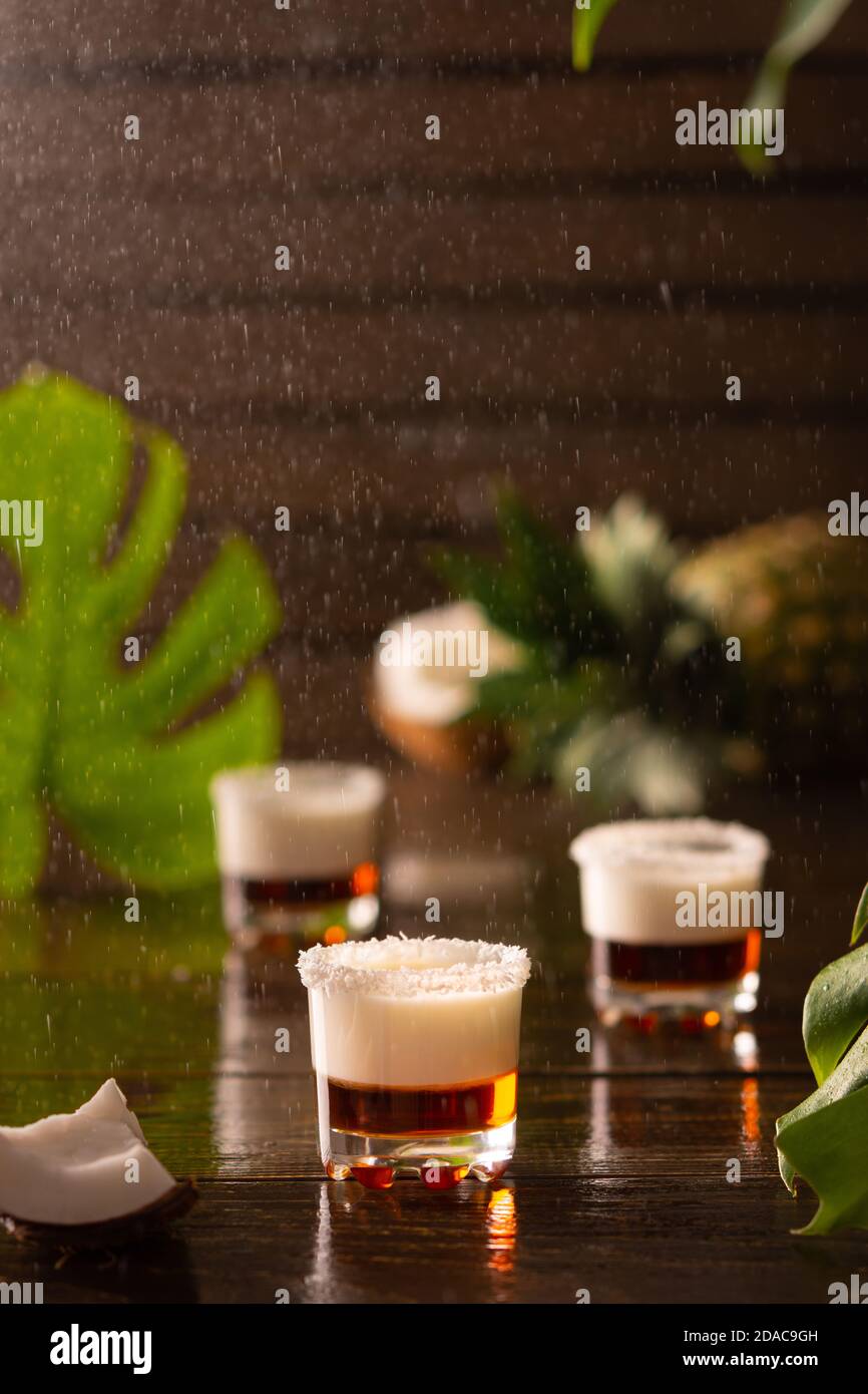 Tropical alcoholic shots decorated with coconut flakes, monstera flower ...