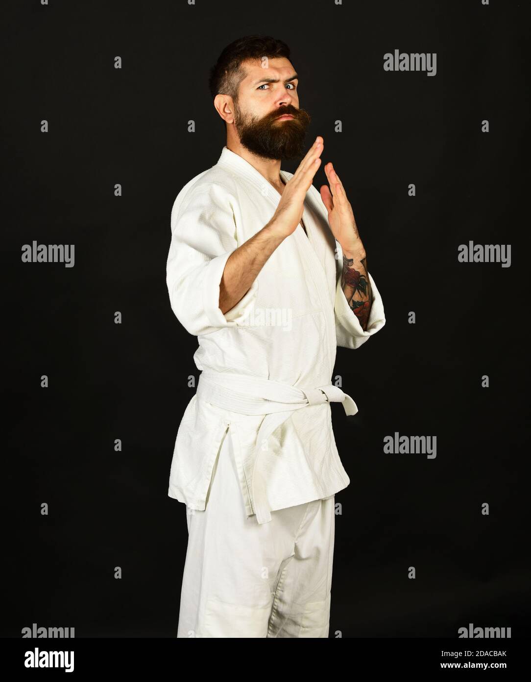 Oriental sports concept. Man with beard in white kimono on black ...