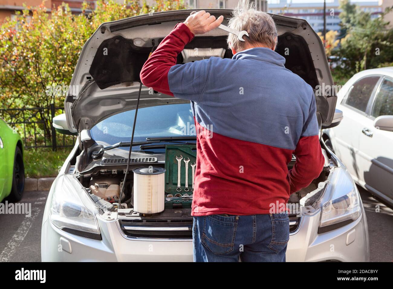 Confused senior man scratching the back of his head while standing ...