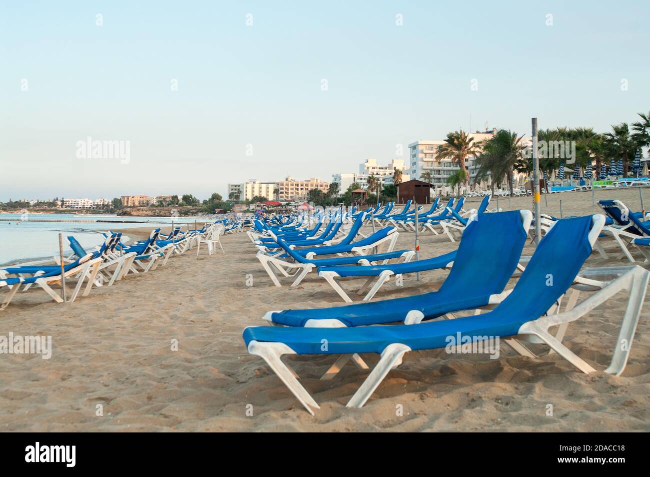 Empty blue sunbeds are on sandy Nissi beach. It is a popular beach in ...