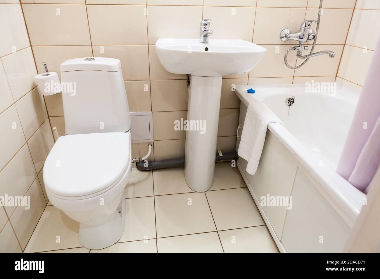 Simple half bathroom with toilet, sink and bath with shower, a white ...