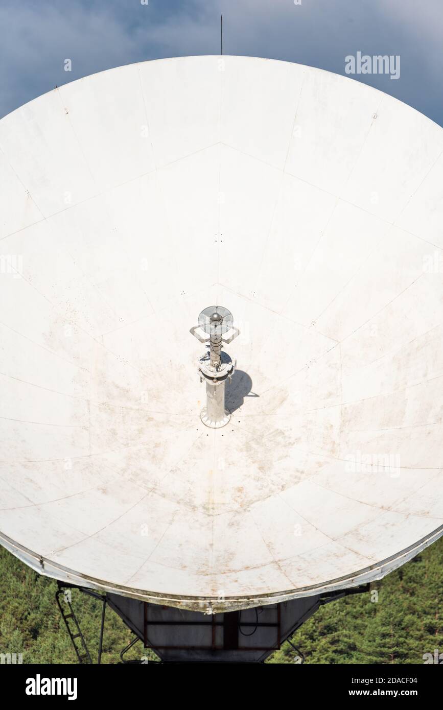 Detail of a giant radio telescope dish pointed skyward on clear blue ...