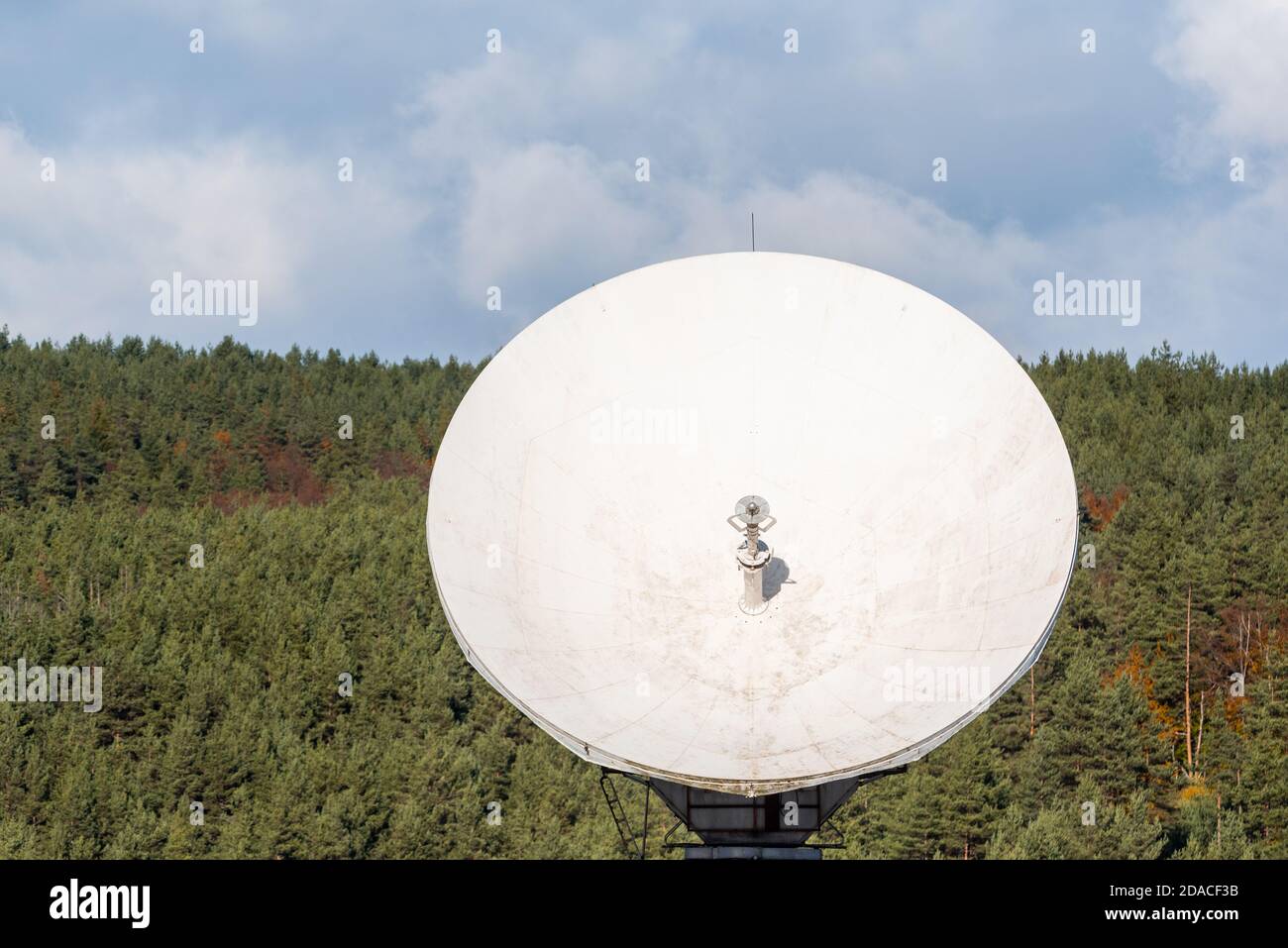 Detail of a giant radio telescope dish pointed skyward on clear blue ...