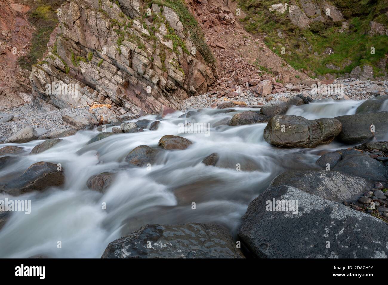 Long exposure of the river Heddon flowing onto the beach at Heddons ...