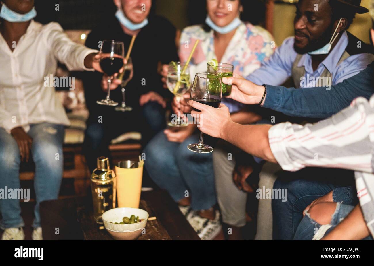 Happy multiracial friends cheering with cocktails at terrace party ...