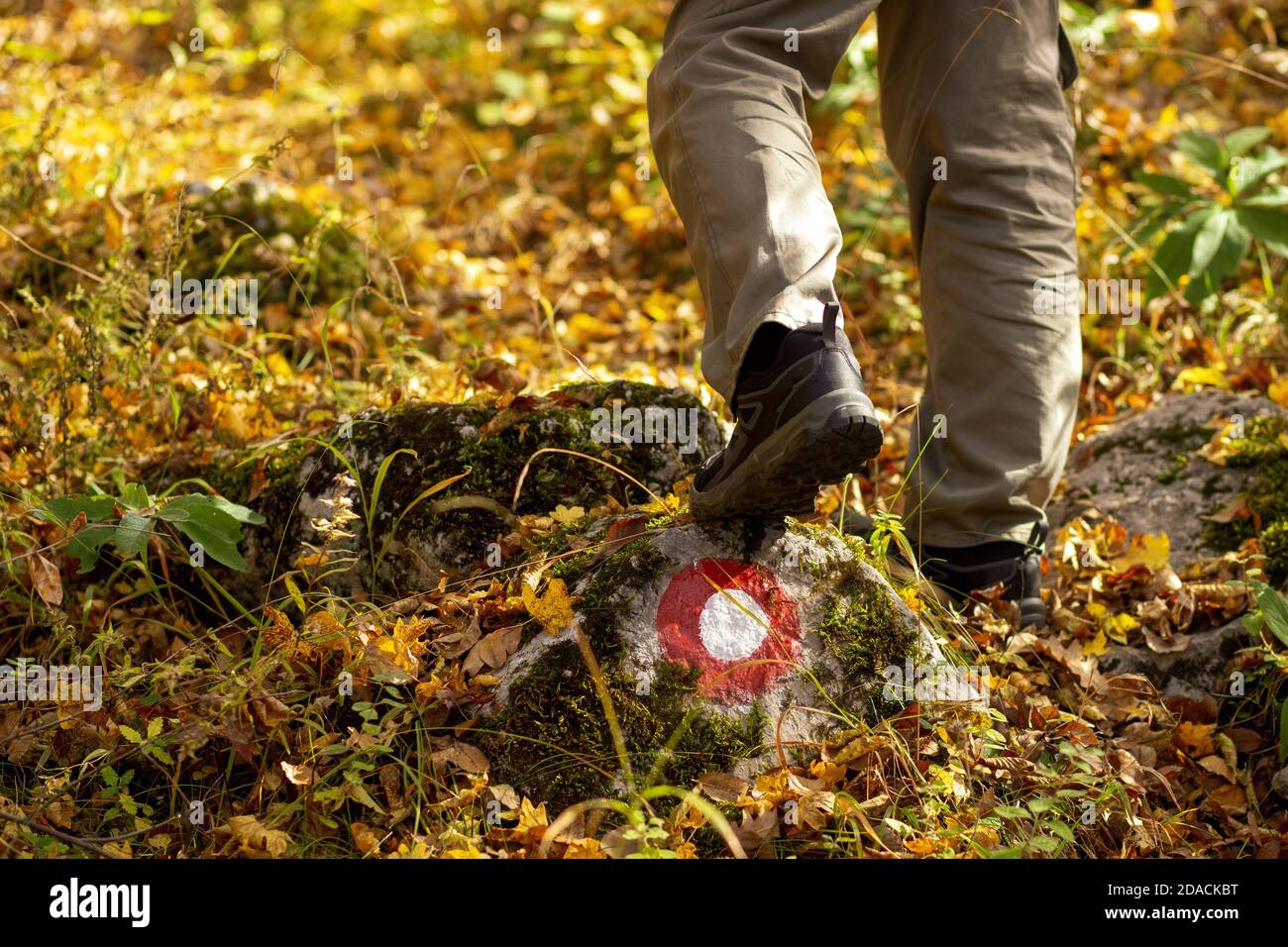 Hiker walking over a stone with a sign on it Stock Photo - Alamy