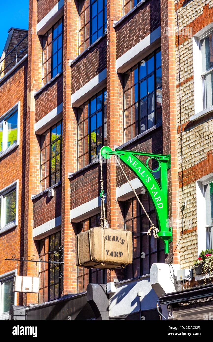 Crane lifting a parcel, sign above the entracne to Neal's Yard in ...