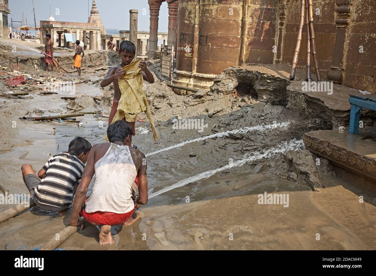 Varanasi, India, December 2011. Young people clean the mud of a Ganges ...