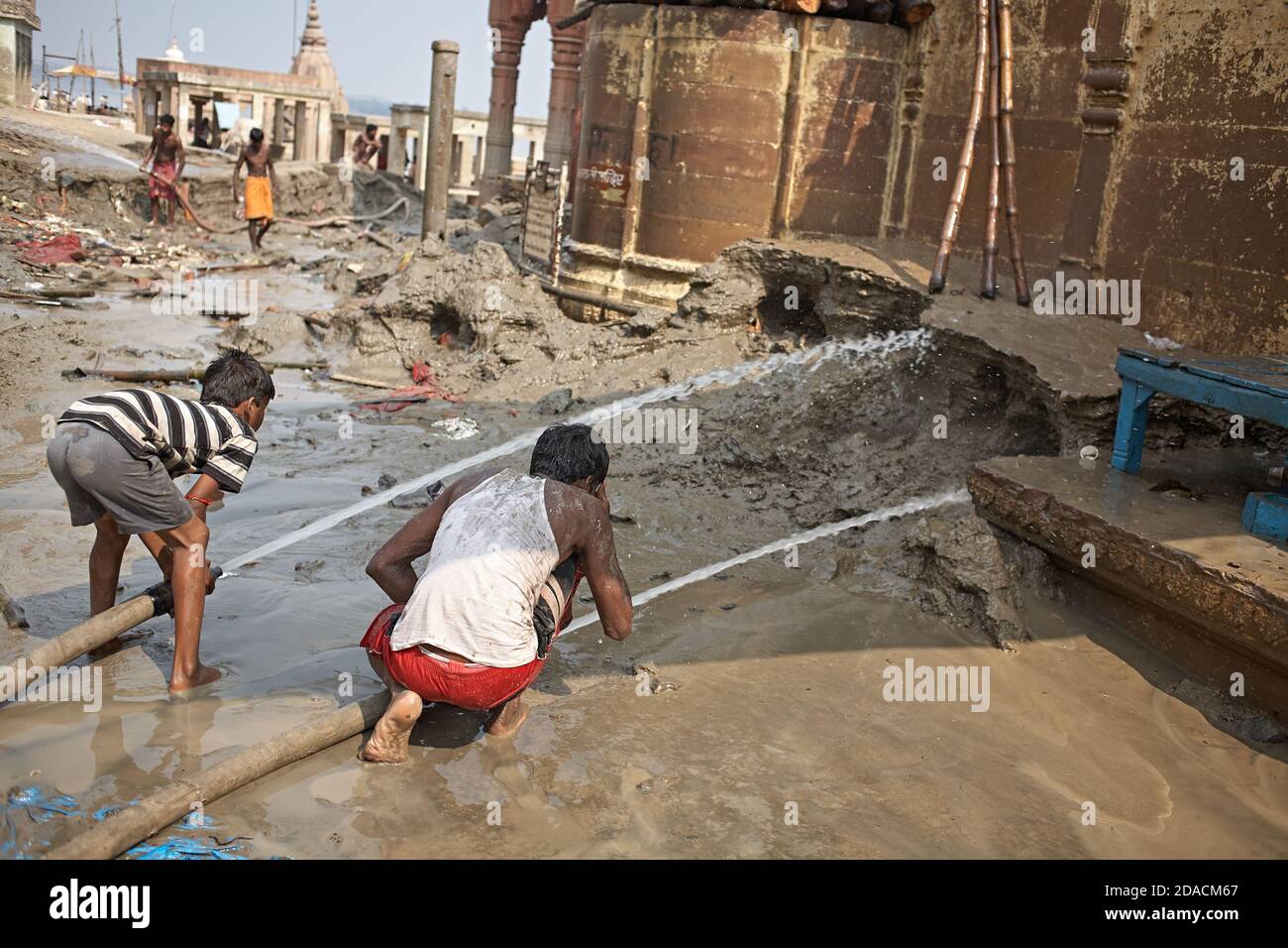 Varanasi, India, December 2011. Young people clean the mud of a Ganges ...